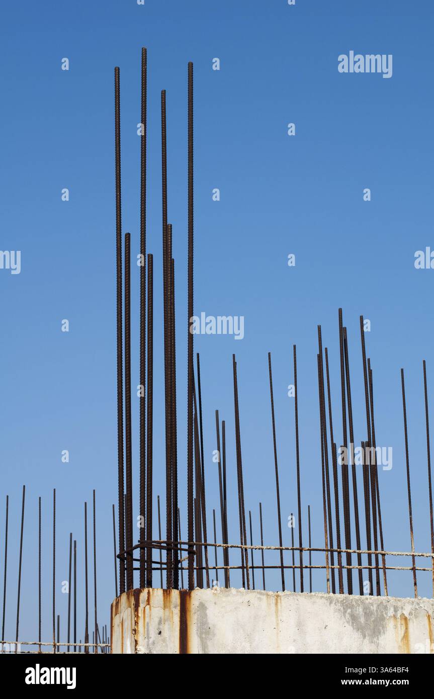 Old reinforcing steel protruding from the concrete. Blue sky background ...