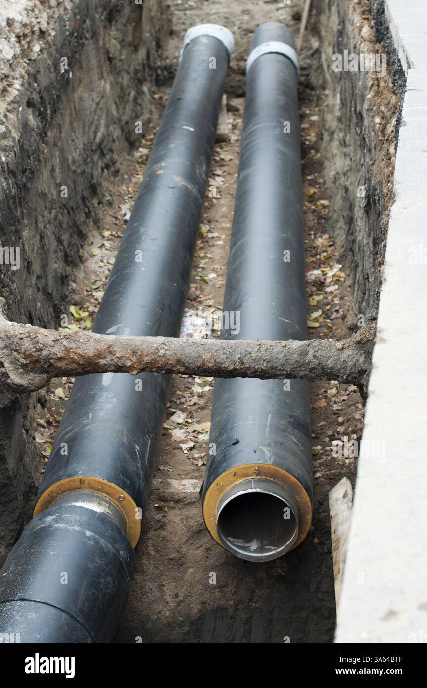 Installing pipes for hot water and steam heating. City heat pipeline ...
