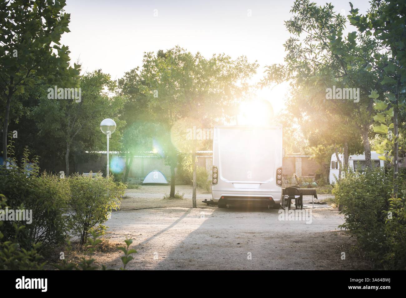 Camper in campsite at the morning sunrise Stock Photo - Alamy
