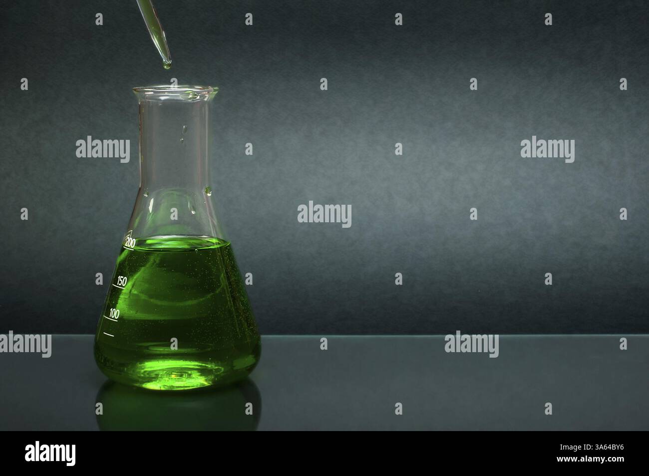 Laboratory beaker filled with green color liquid substances and ...