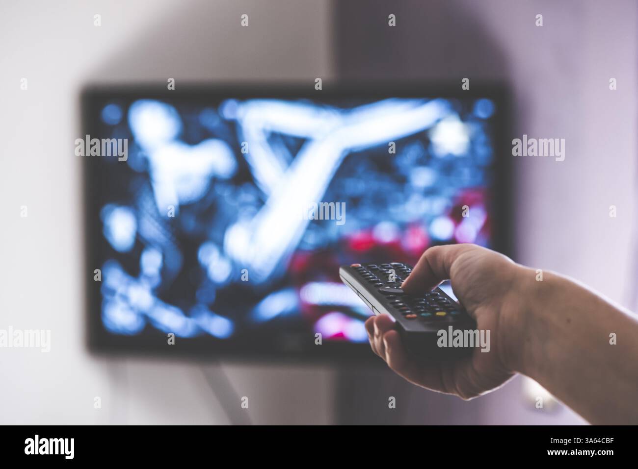 TV and remote control. Hand hold remote Stock Photo - Alamy