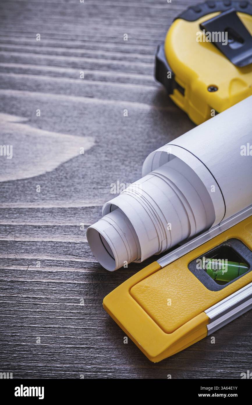 Blueprints tape-line and construction level on vintage wooden board ...