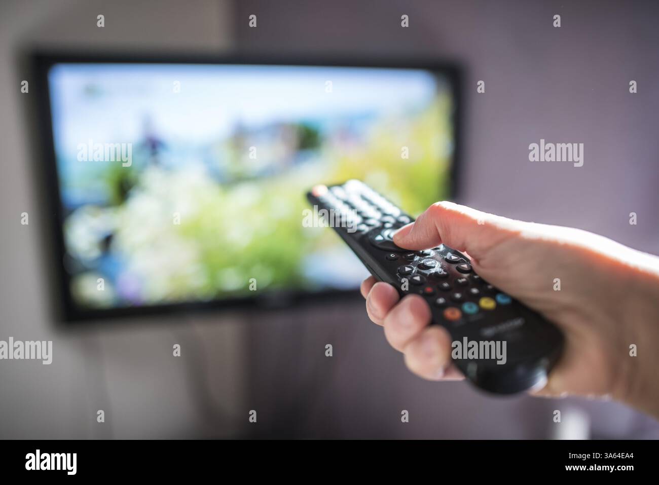 TV and remote control. Hand hold remote Stock Photo - Alamy