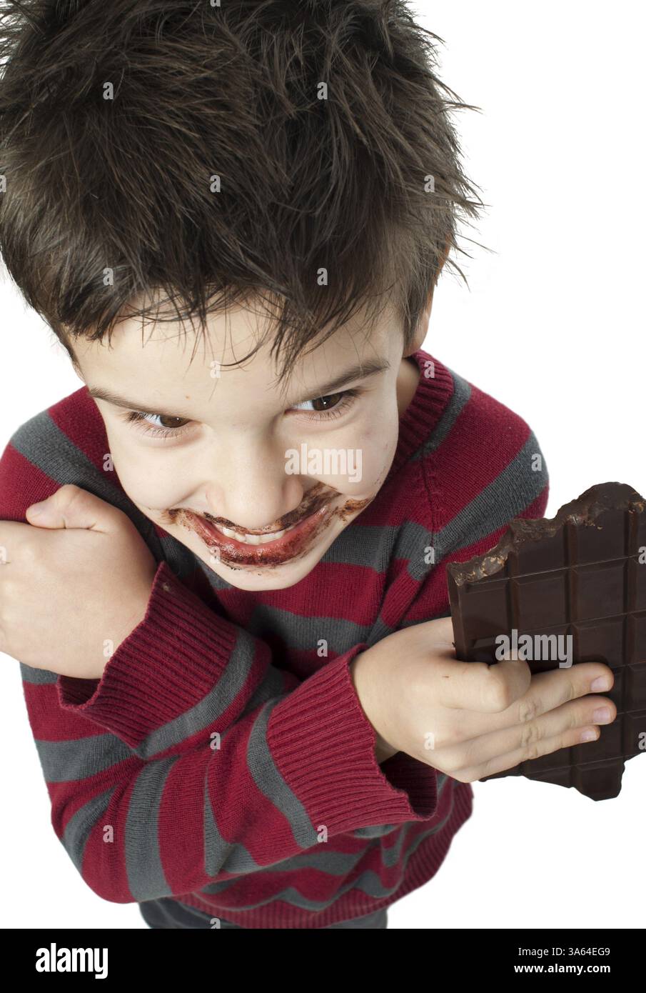 Smiling kid eating chocolate. Smeared stained with chocolate lips ...