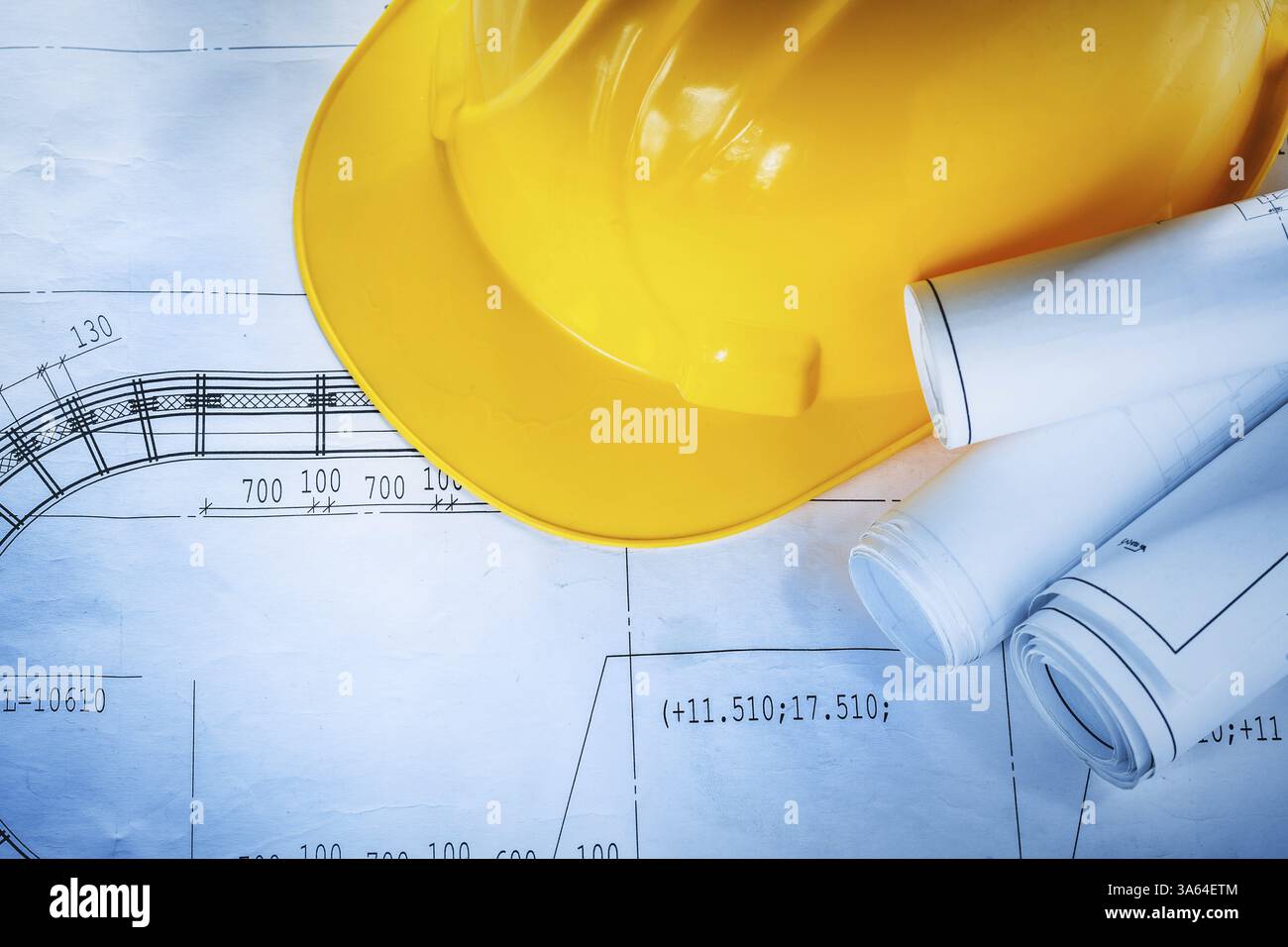 Safety building helmet construction plans on blueprint Stock Photo - Alamy