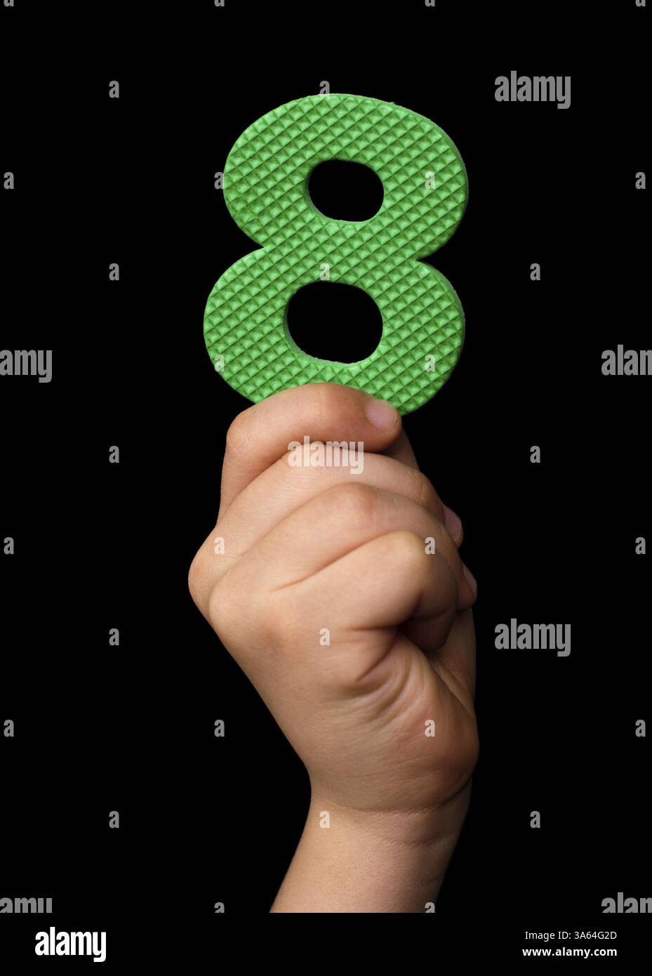 Children hand holding the number Eight. Black isolated green color ...