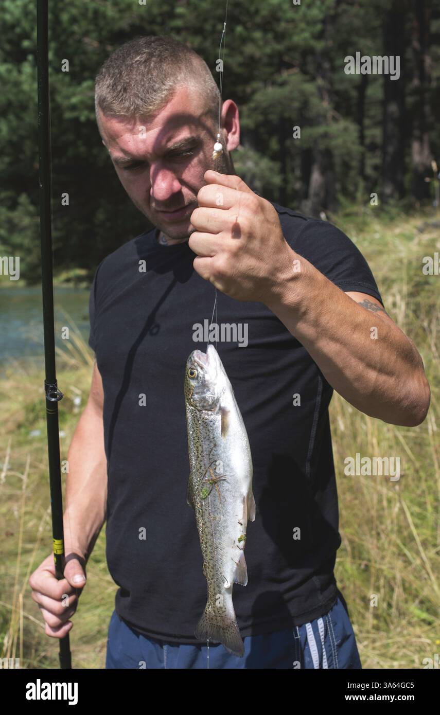 Fisherman caught a fish in mountain dam. Bulgaria Stock Photo - Alamy