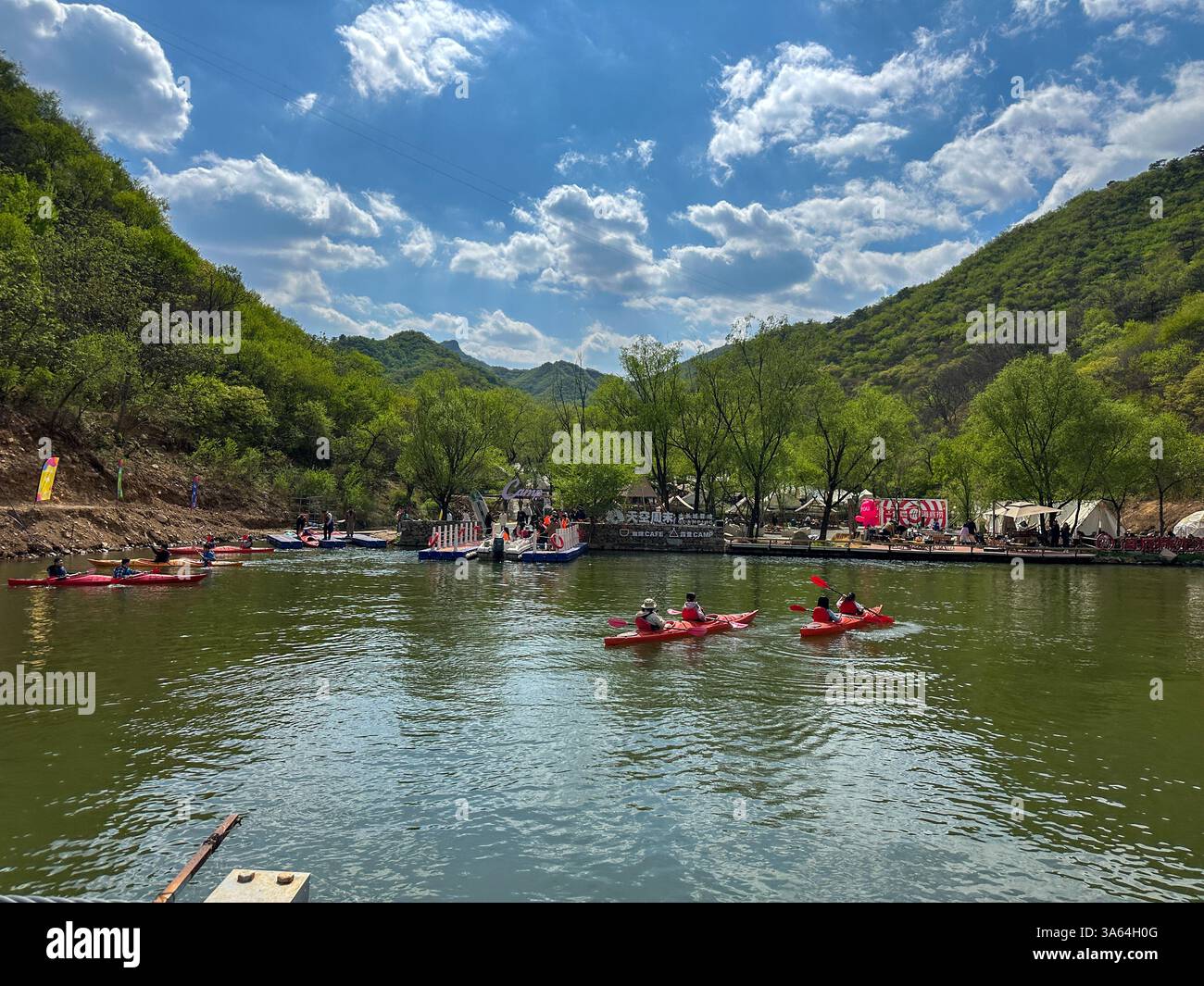Tourists play in Kayaks in the reservoir beneath the Great Wall Stock ...