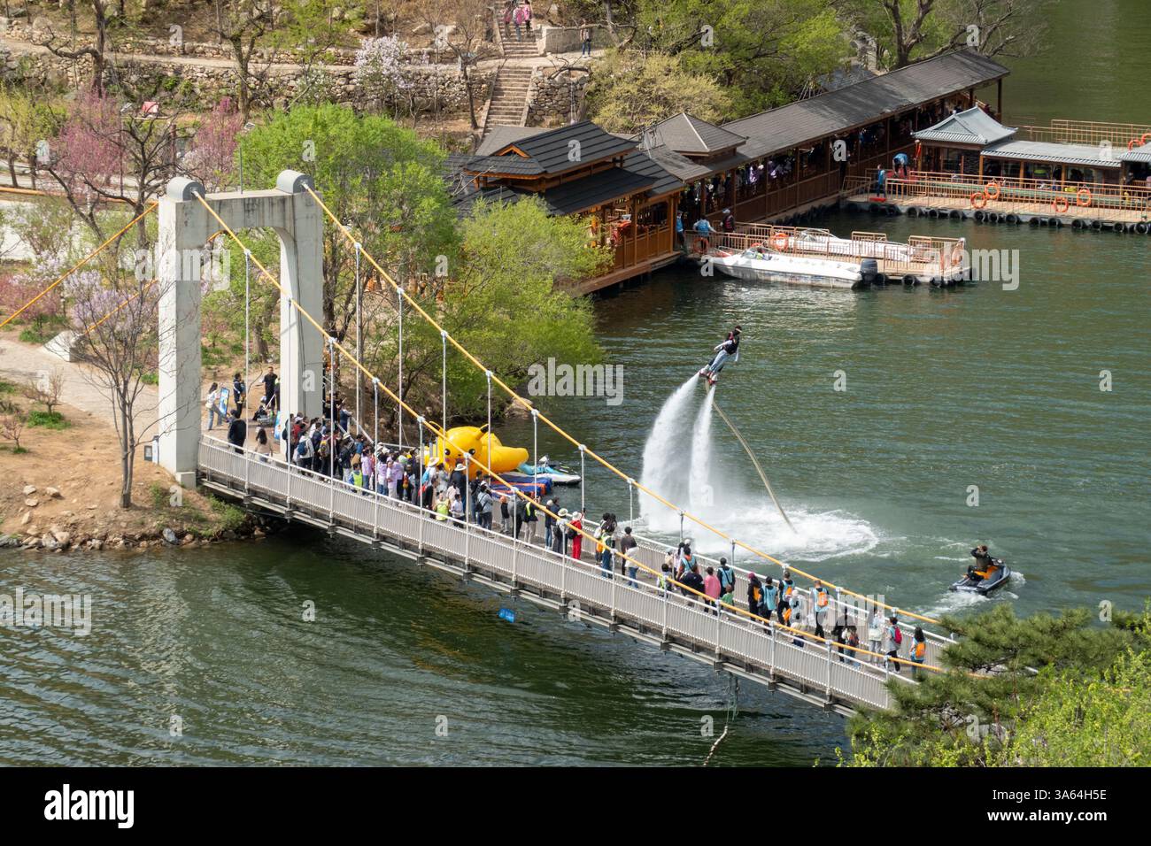 A Flyboarder performs to an audience in the park below the Great Wall ...