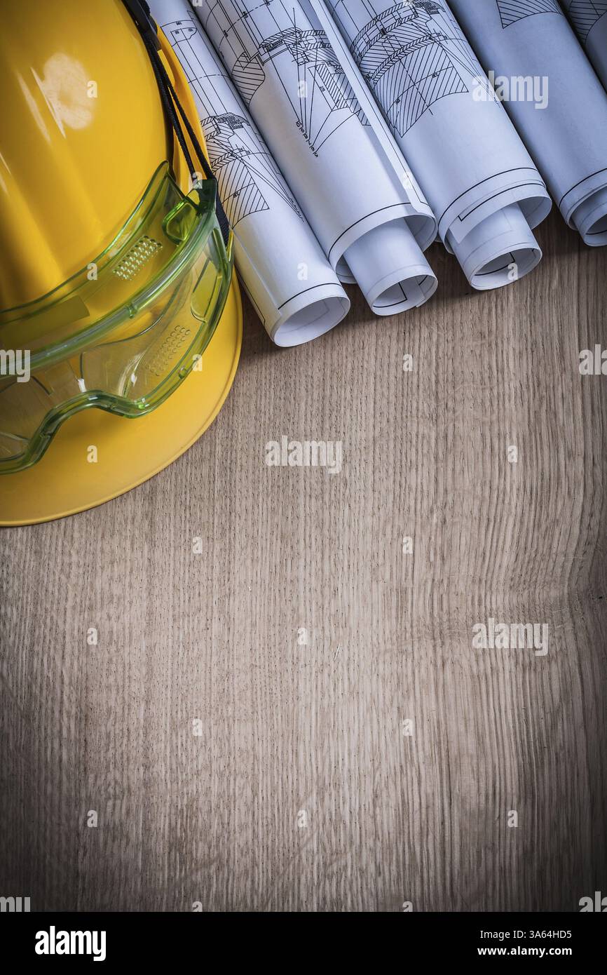 Protective spectacles rolled blueprints and building helmet ...