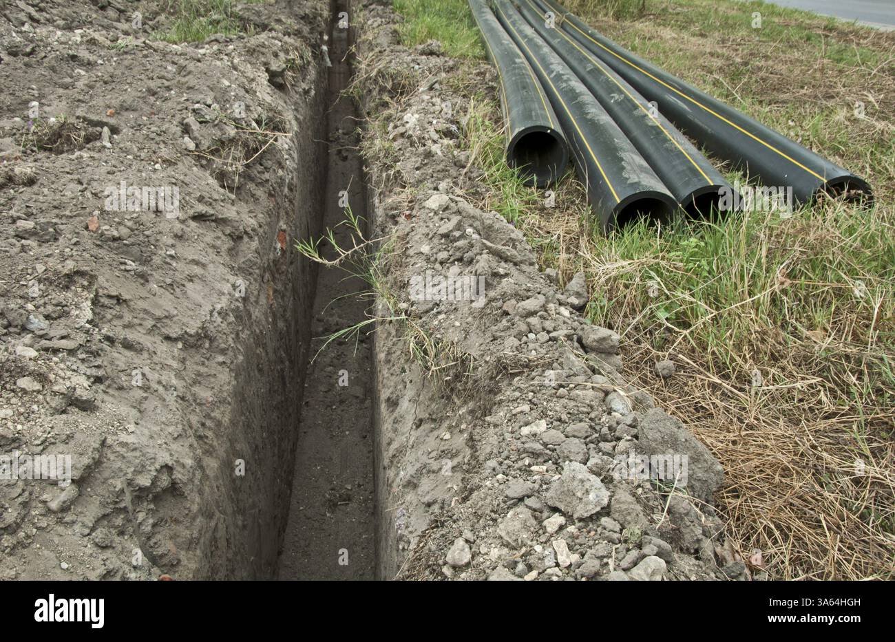 Black deep plastic pipes and ditch Stock Photo - Alamy