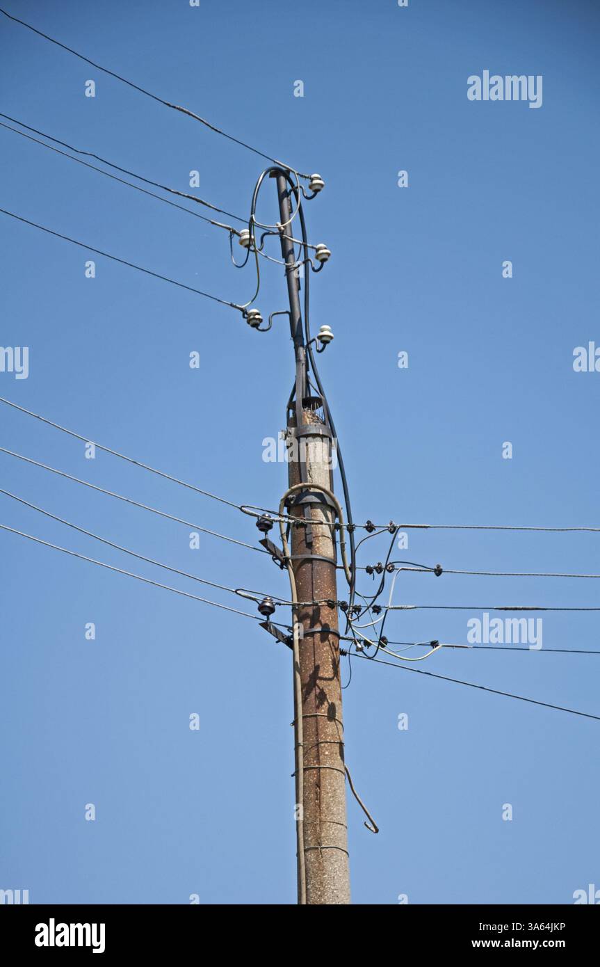 Old electrical wiring. Column on blue sky background Stock Photo - Alamy