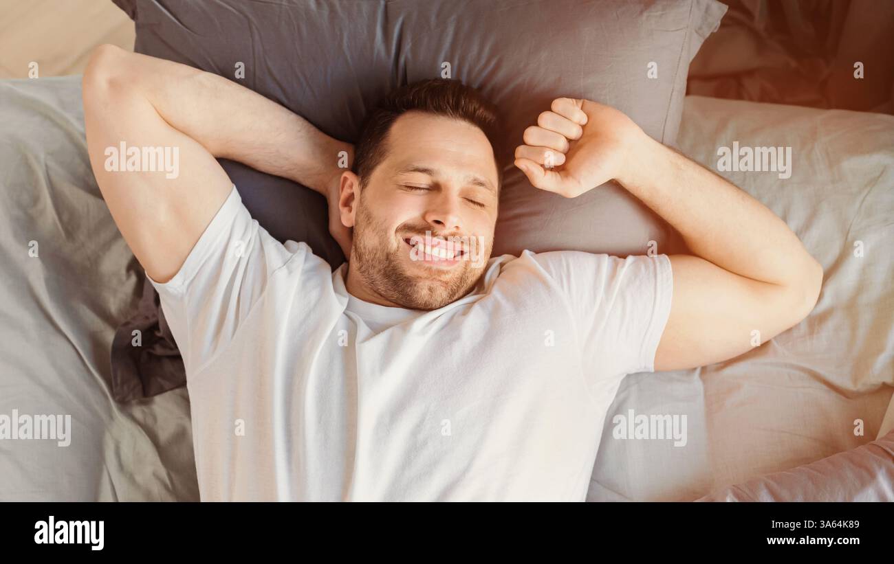 Man Waking Up Lying In Bed At Home, Above-View, Panorama Stock Photo ...