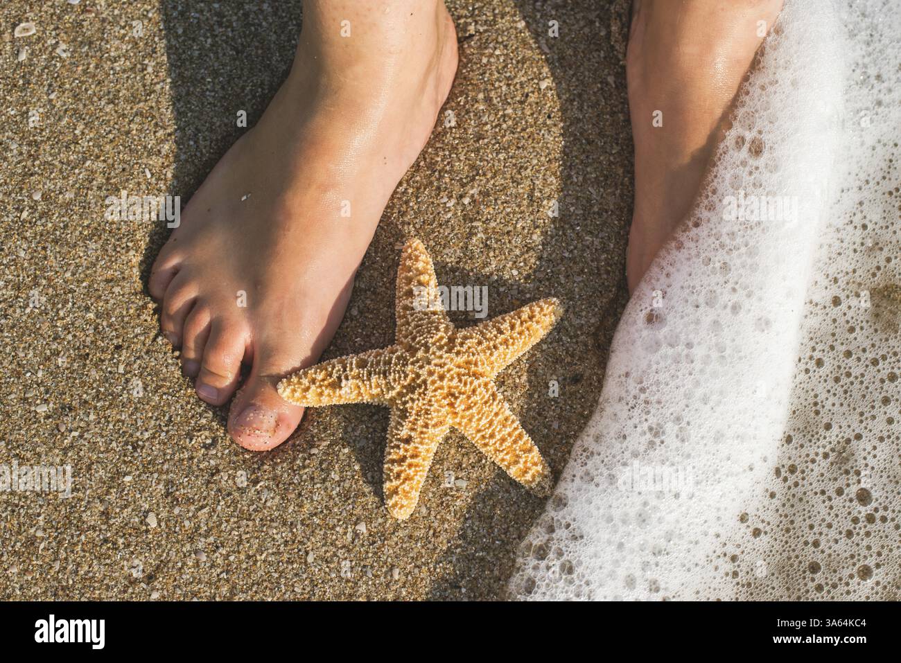 Starfish and feet on the beach. Sea waves Stock Photo - Alamy