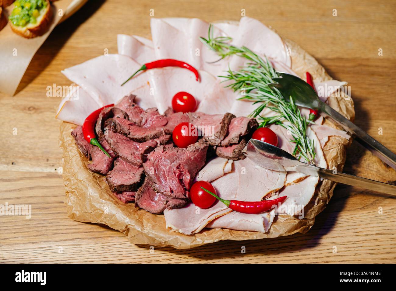 Top view of a charcuterie platter featuring sliced roast beef, ham ...