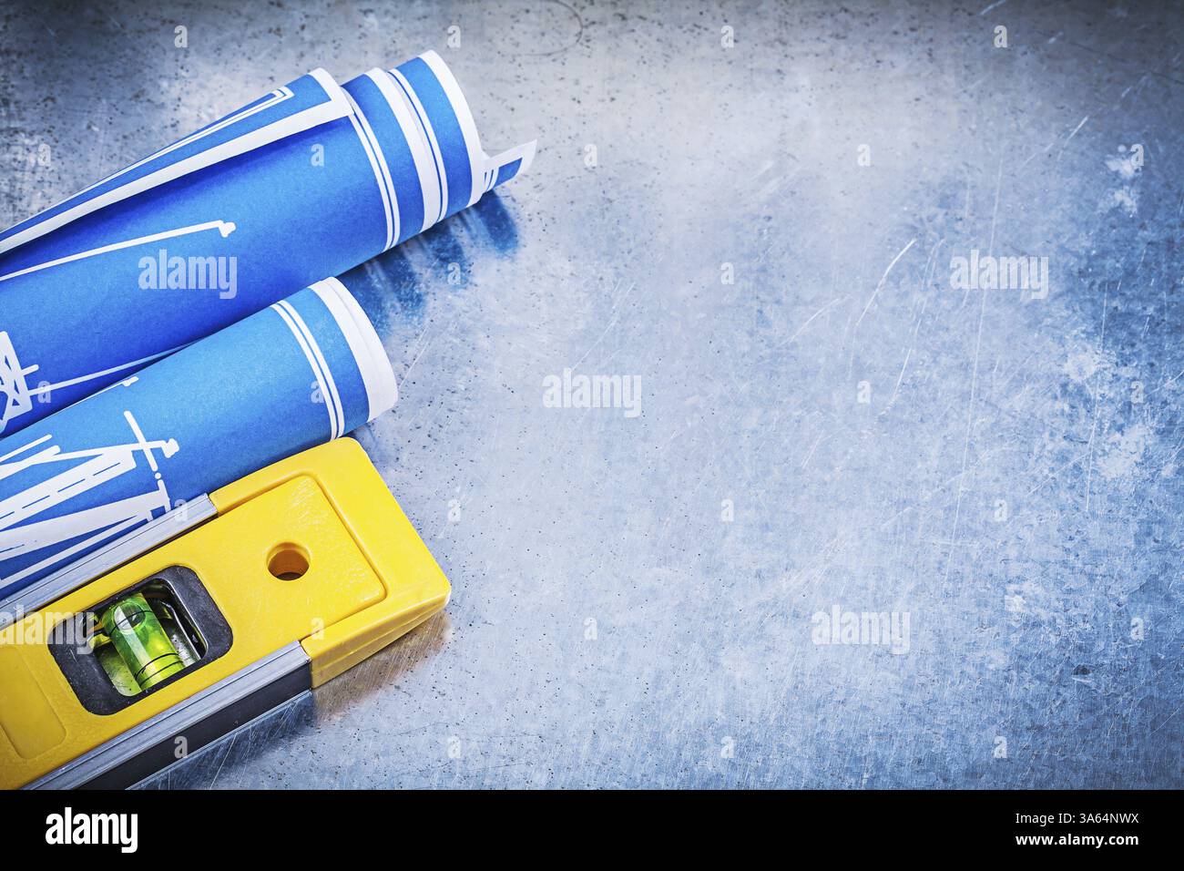 Rolled up engineering drawings construction level on metallic ...