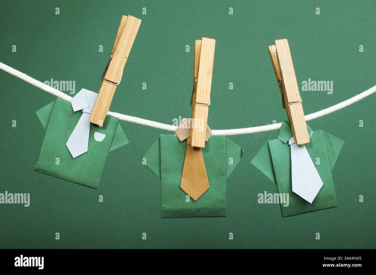 Origami shirts on rope. Green background Stock Photo - Alamy