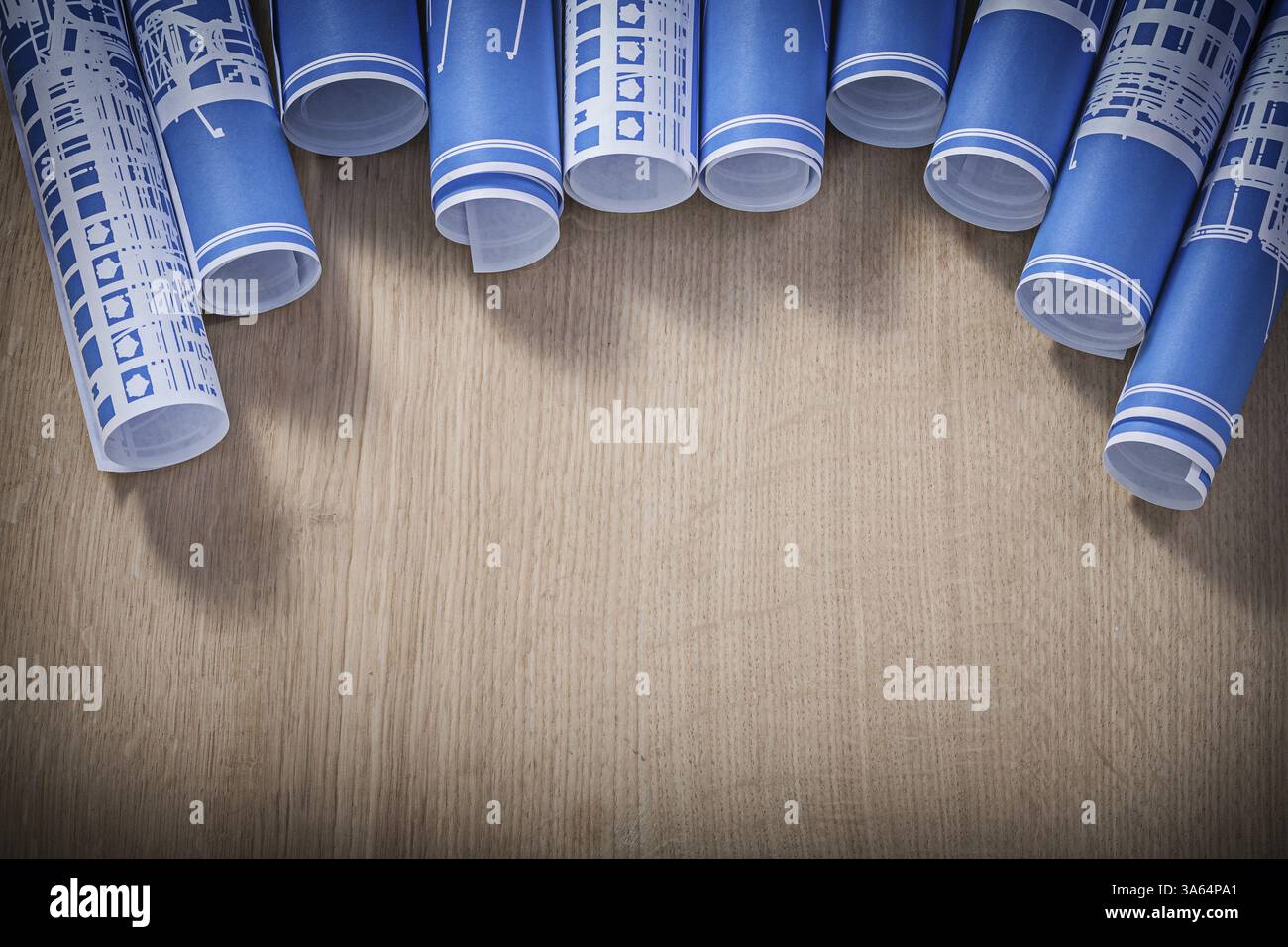 Collection of blue rolled construction drawings on wooden board Stock ...