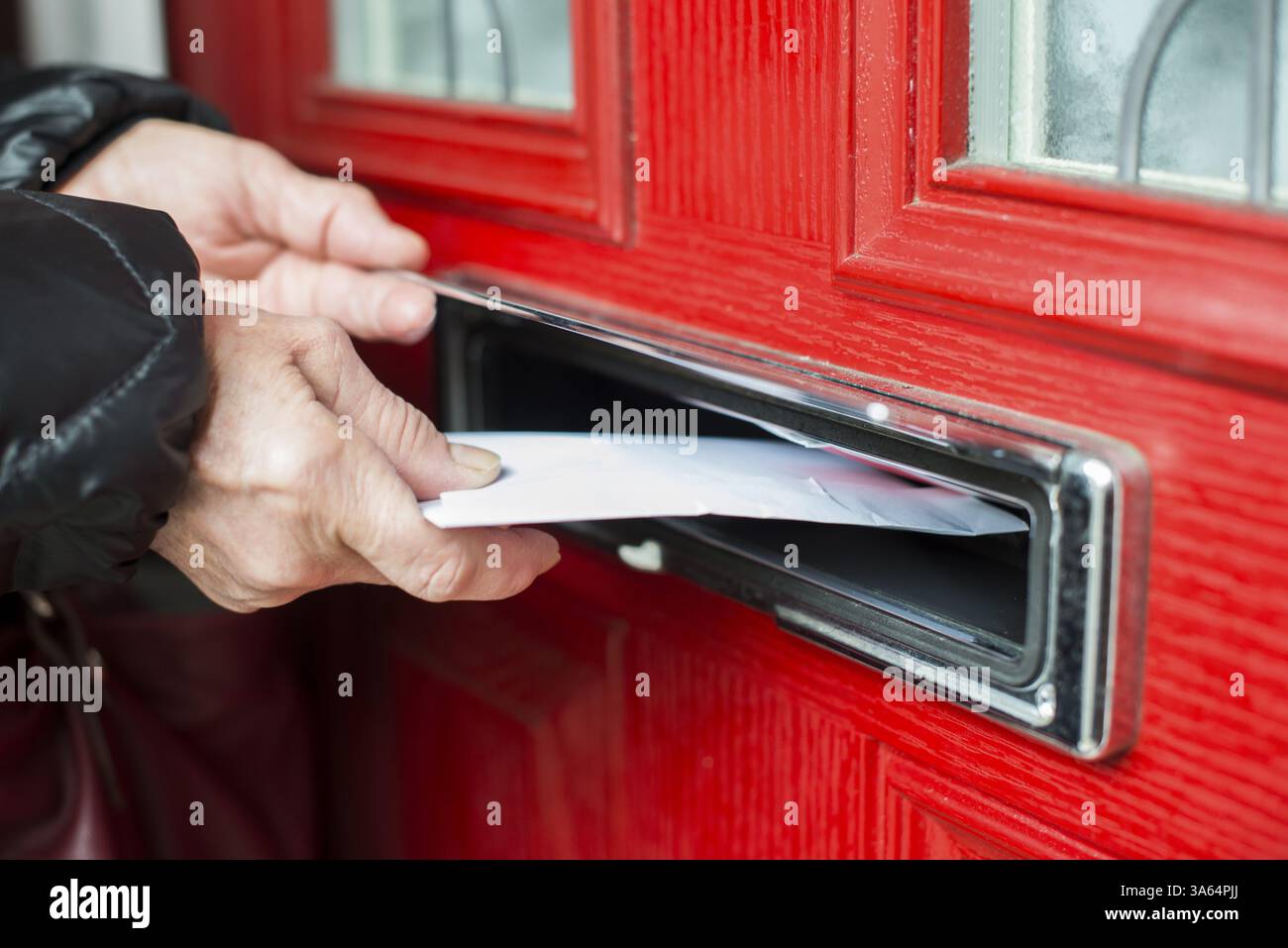 Hand putting Letter in a red mailbox Stock Photo - Alamy