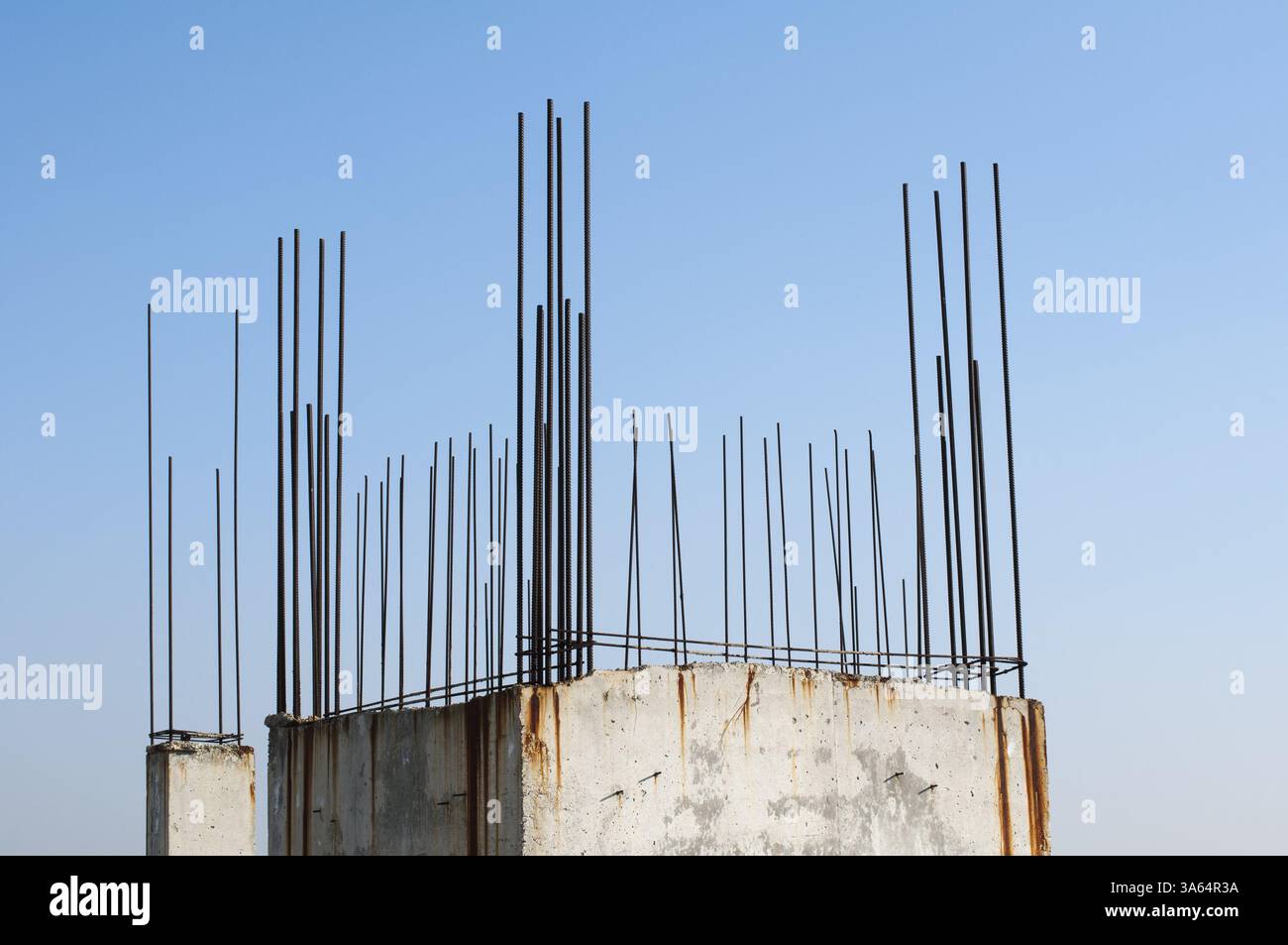 Old reinforcing steel protruding from the concrete. Blue sky background ...