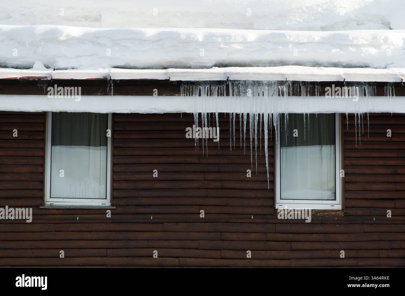 Icicles on window. Wooden house windows Stock Photo - Alamy