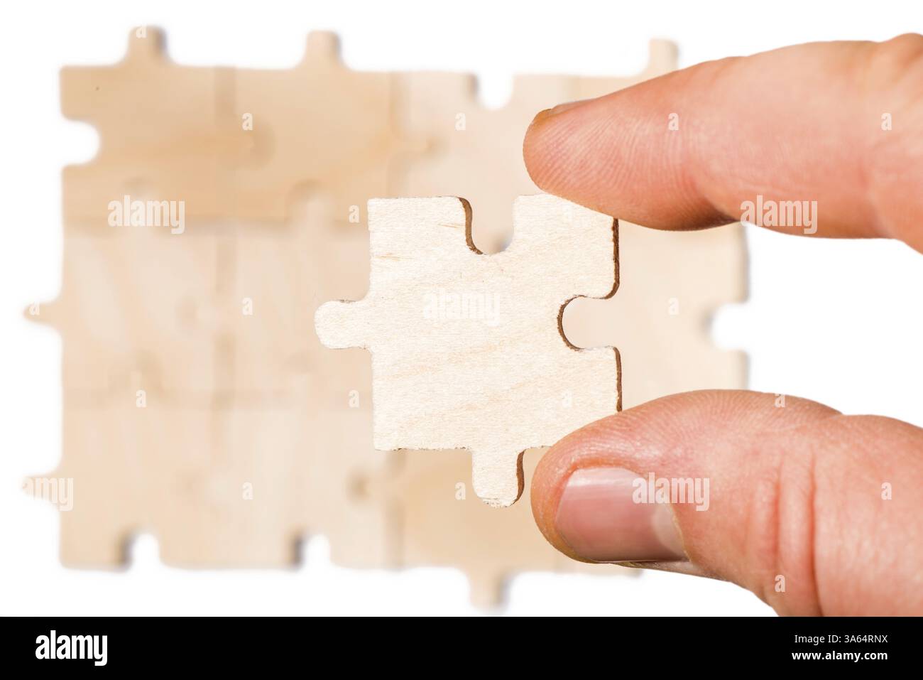 Wooden puzzle on white background. Hand holding puzzle piece. White ...