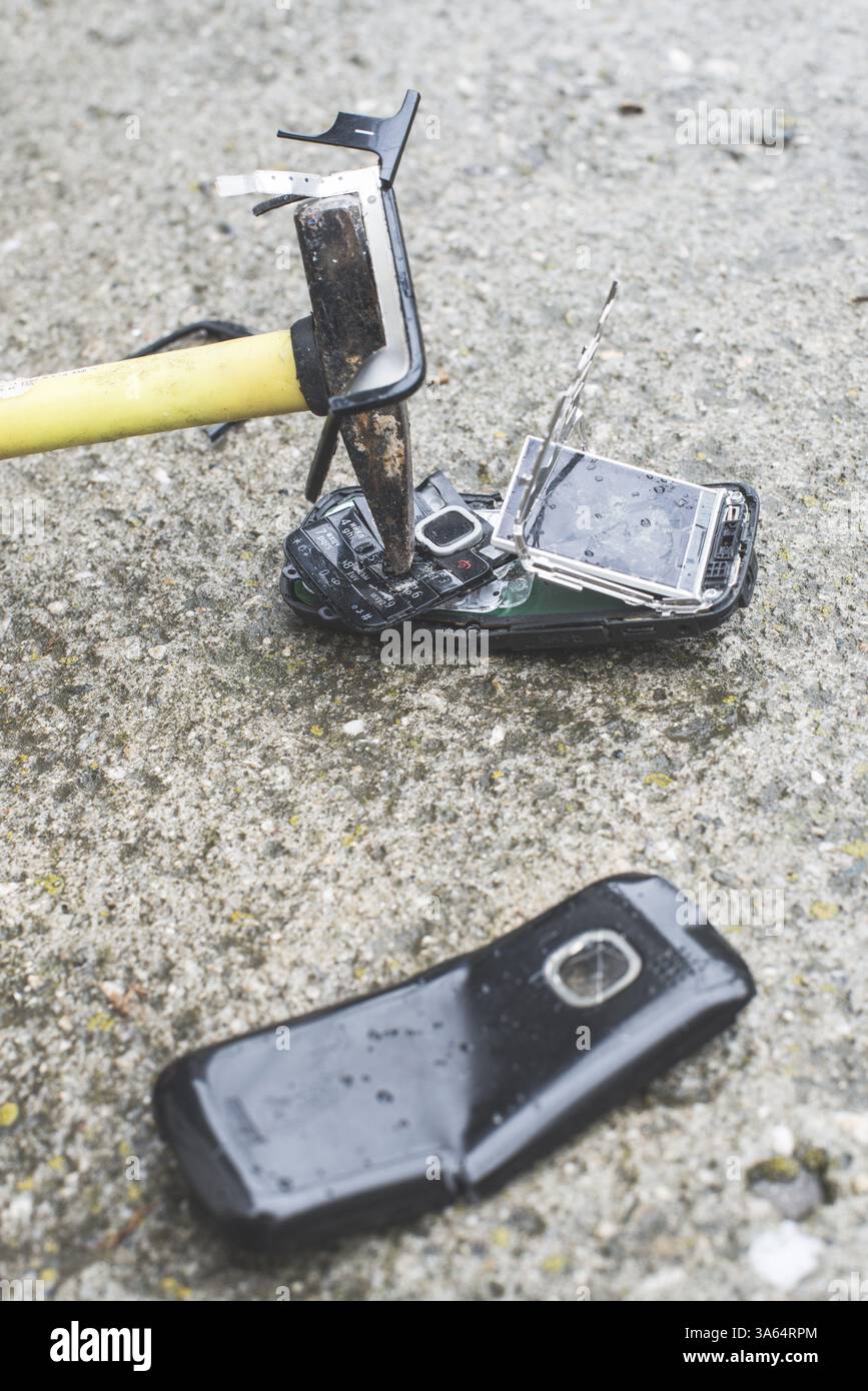 Old broken mobile phone. Hammer crease phone Stock Photo - Alamy