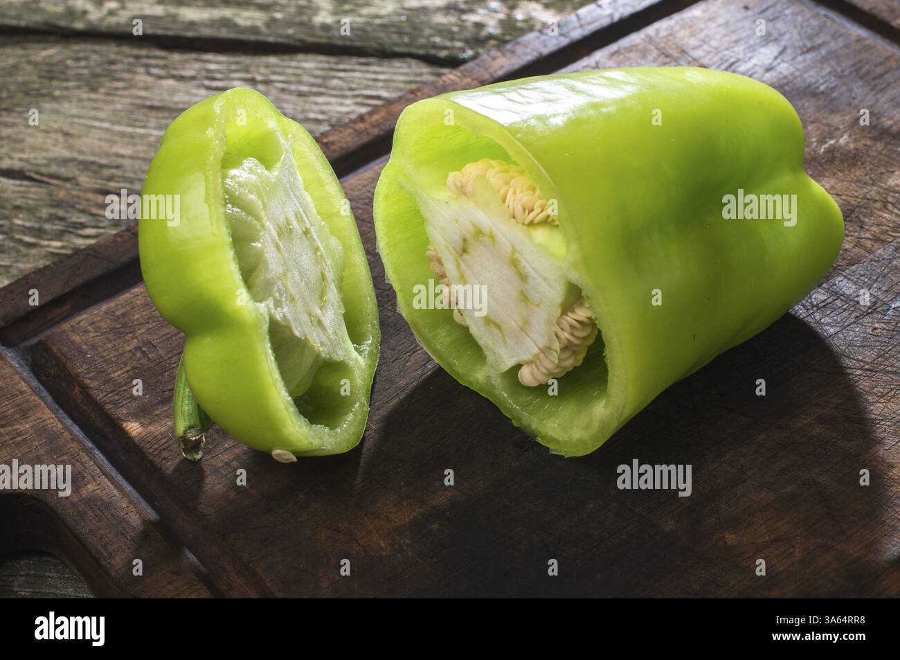 Cut green pepper on wood. Backlight Stock Photo - Alamy