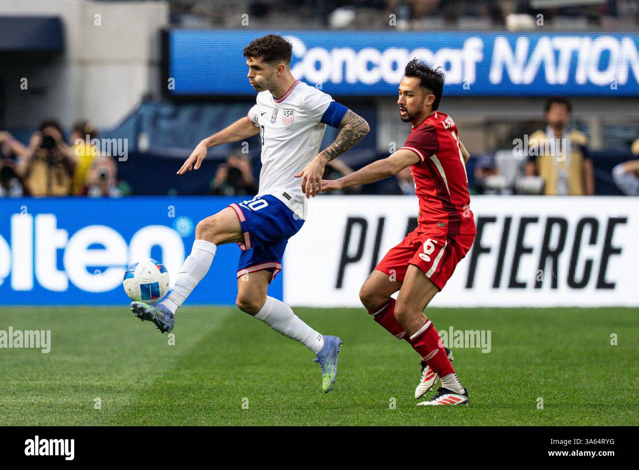 United States forward Christian Pulisic (10) is defended by Canada ...