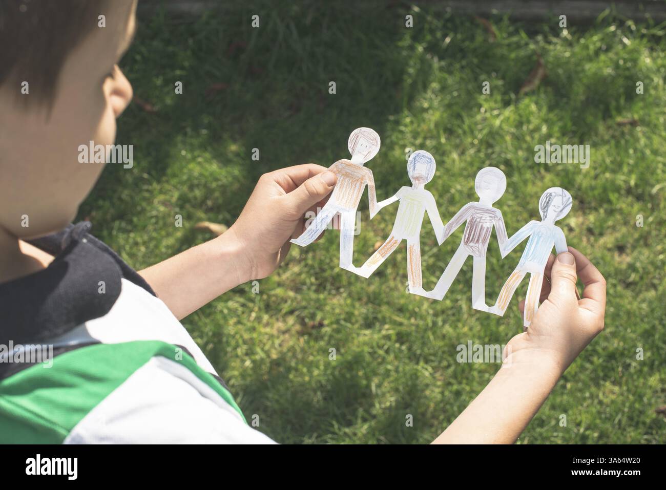 Child hold paper made people figures. Painted figures Stock Photo - Alamy