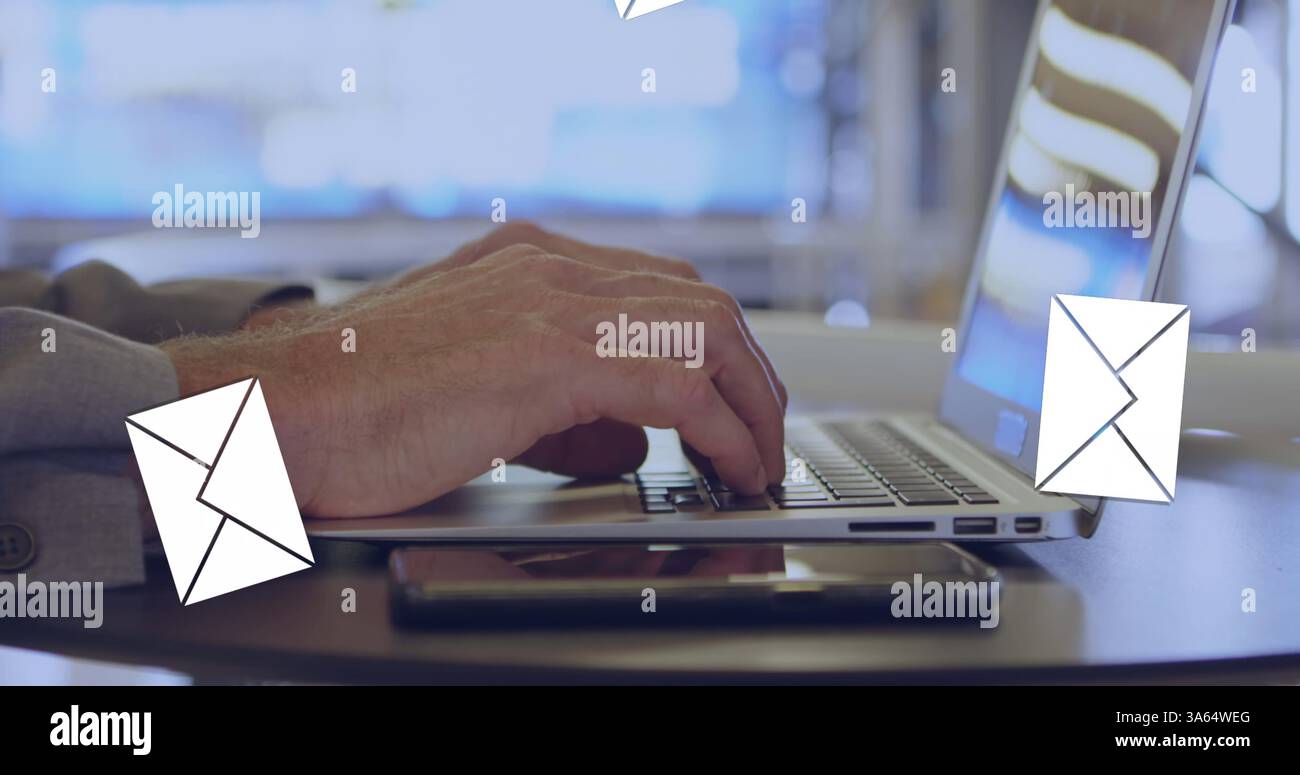 Typing on laptop, hands sending emails with smartphone on table nearby ...