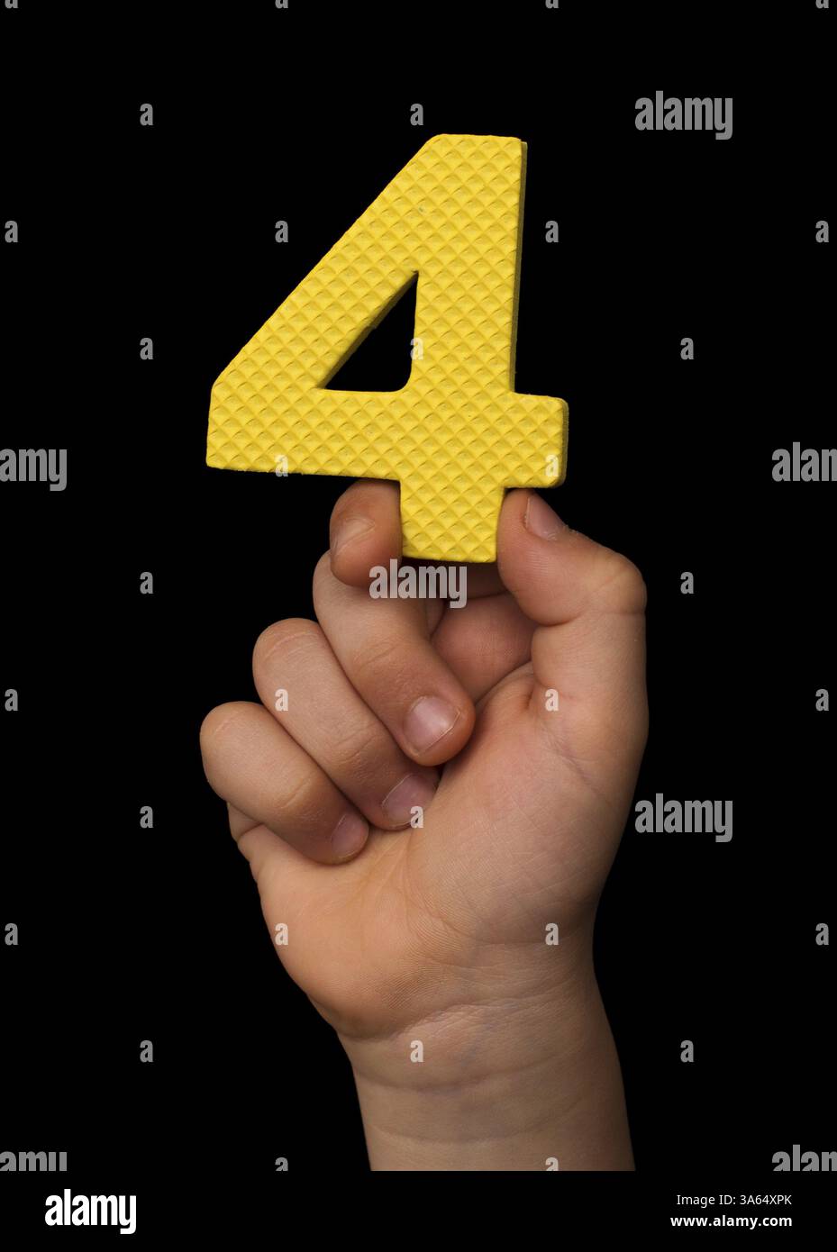 Children hand holding the number Four. Black isolated yellow number ...