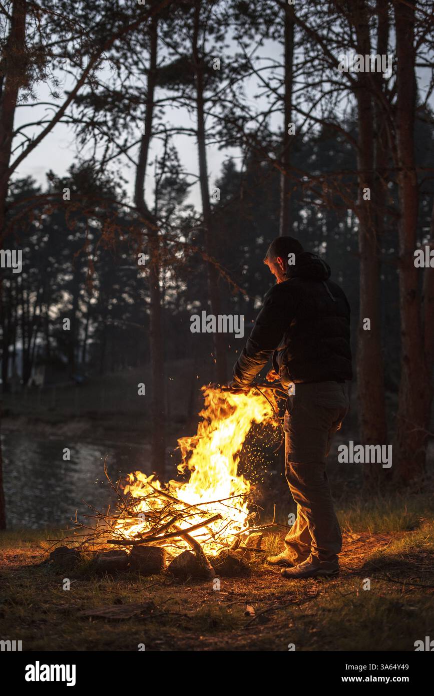 Man lights a fire in the fireplace in nature at night Stock Photo - Alamy