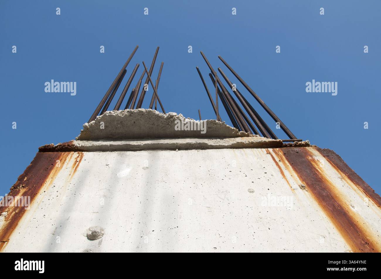 Old reinforcing steel protruding from the concrete. Blue sky background ...