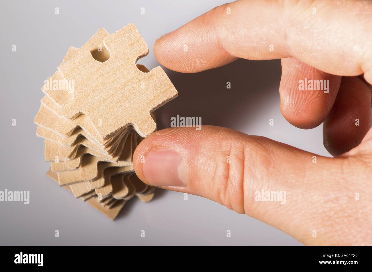 Wooden puzzle on white background. Pile of puzzle. Hand holding puzzle ...