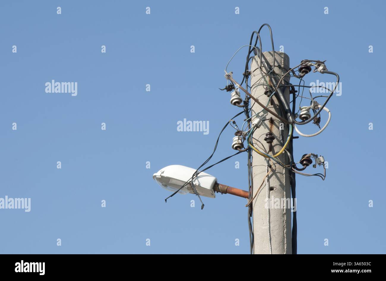 Old electrical wiring. Column on blue sky background Stock Photo - Alamy