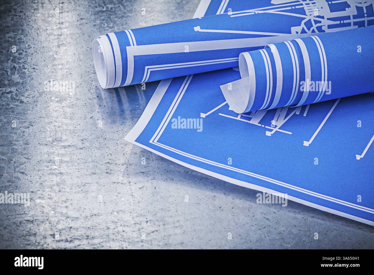 Pile of blue blueprints on metallic background construction concept ...