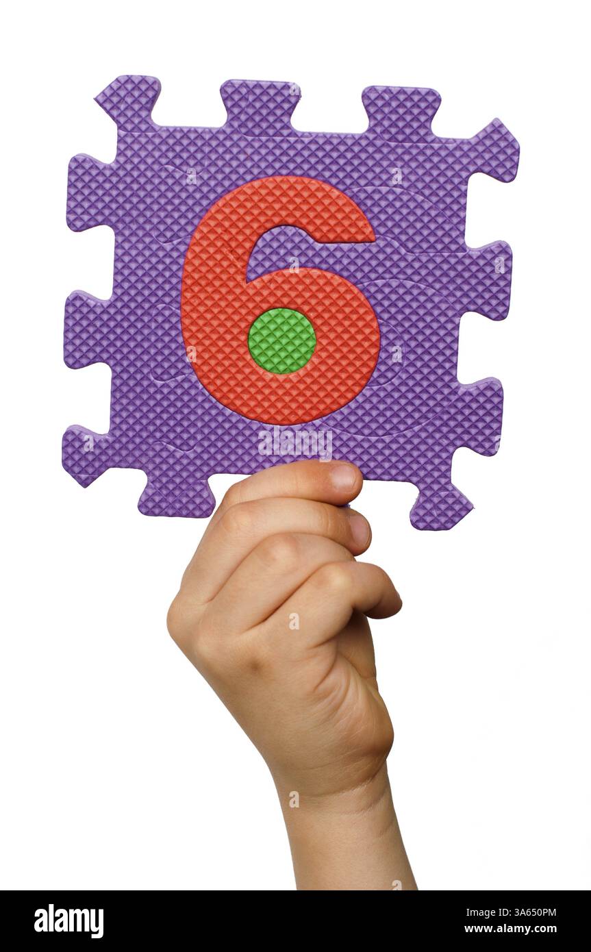 Children hand holding the number Six. White isolated multicolor number ...