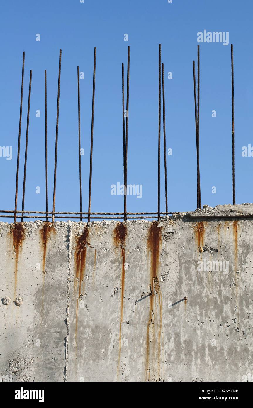 Old reinforcing steel protruding from the concrete. Blue sky background ...