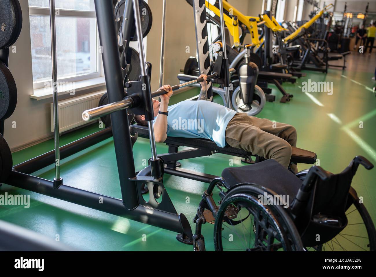Disabled athlete strengthens body by lifting barbell in gym, healthy ...