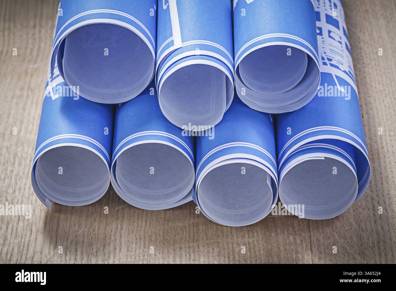 Composition of rolled up construction drawings on wooden board Stock ...
