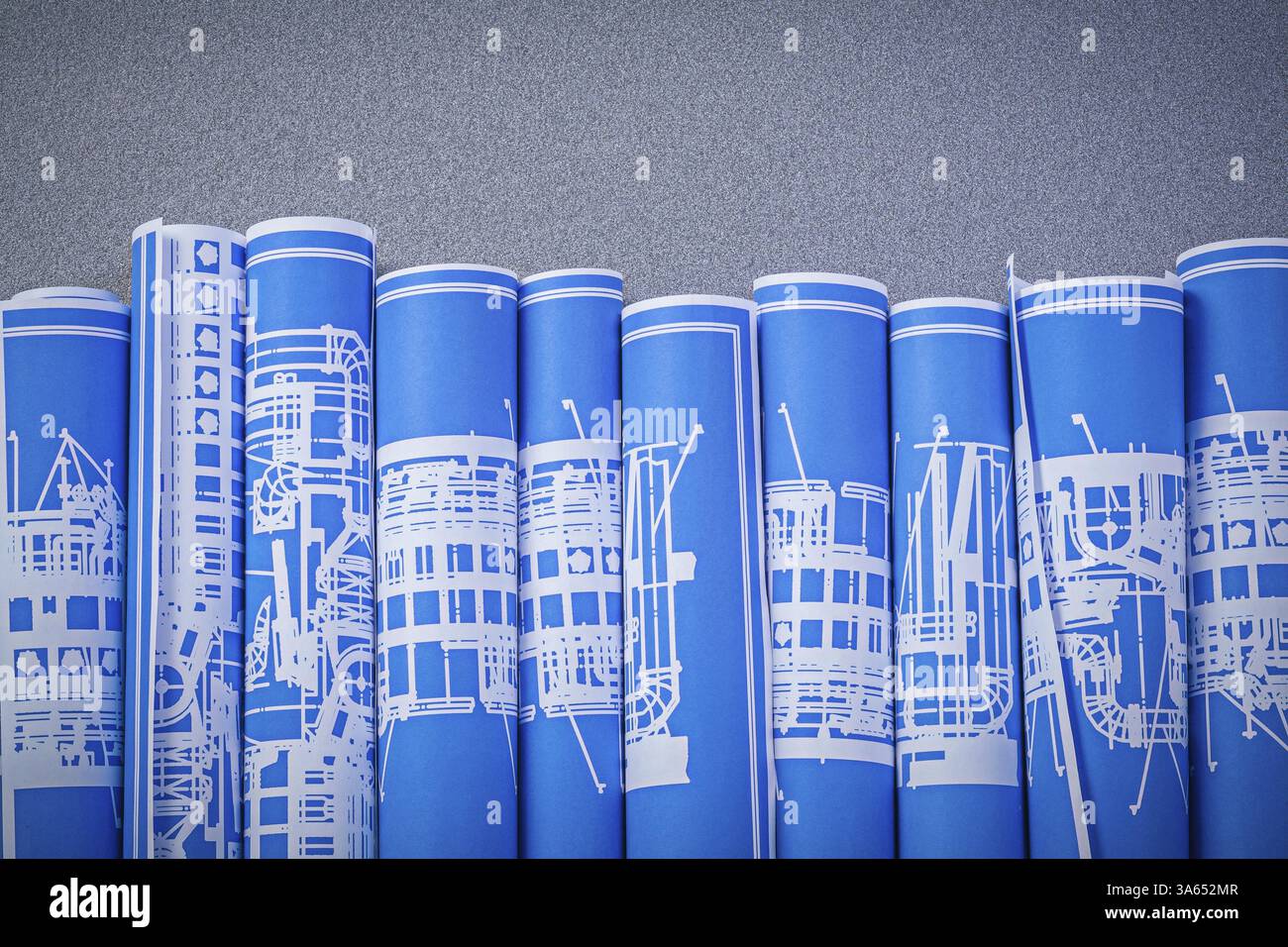 Collection of blue rolled up engineering drawings on grey background ...