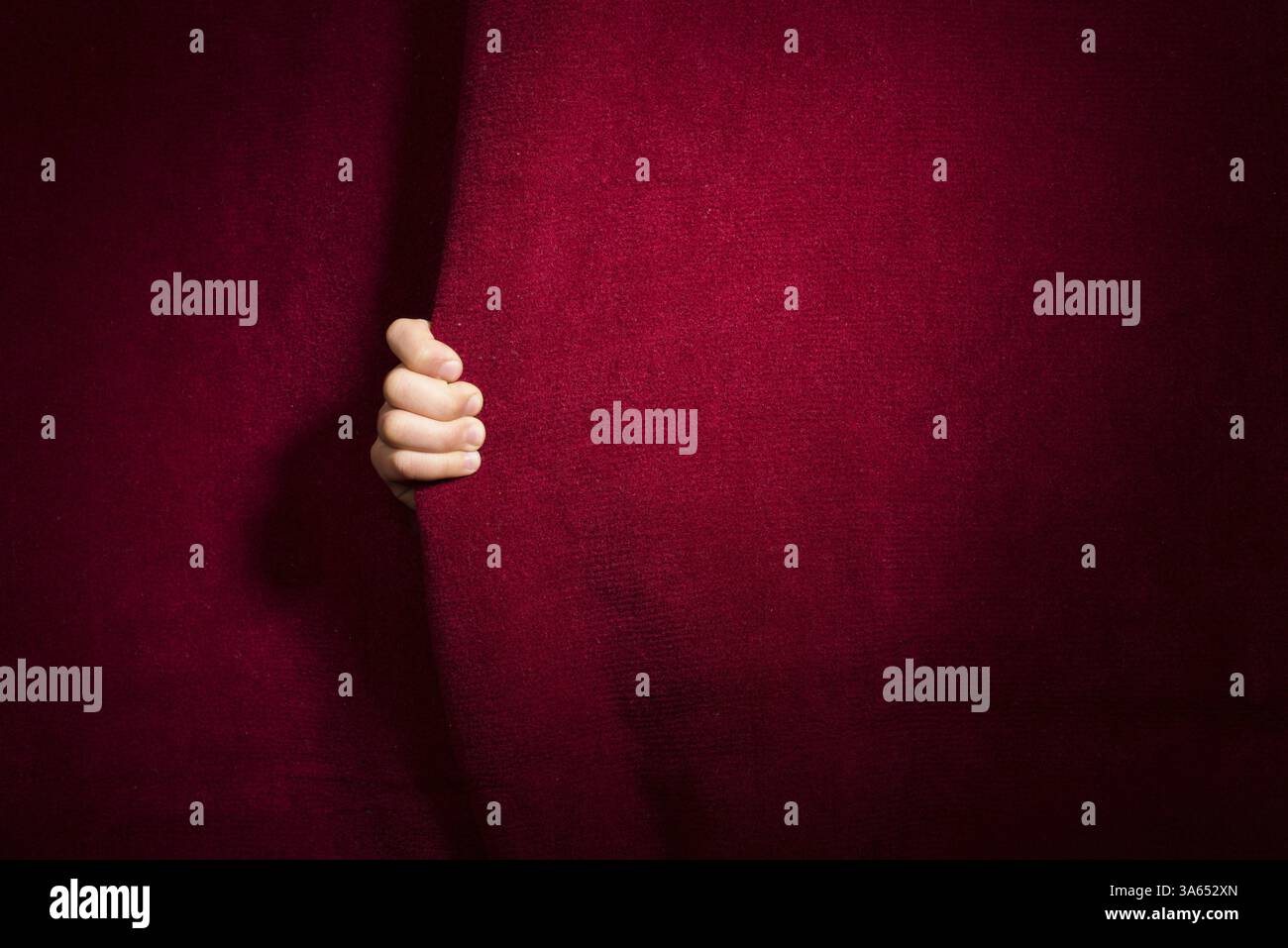 Hand appearing beneath the curtain. Red curtain Stock Photo - Alamy