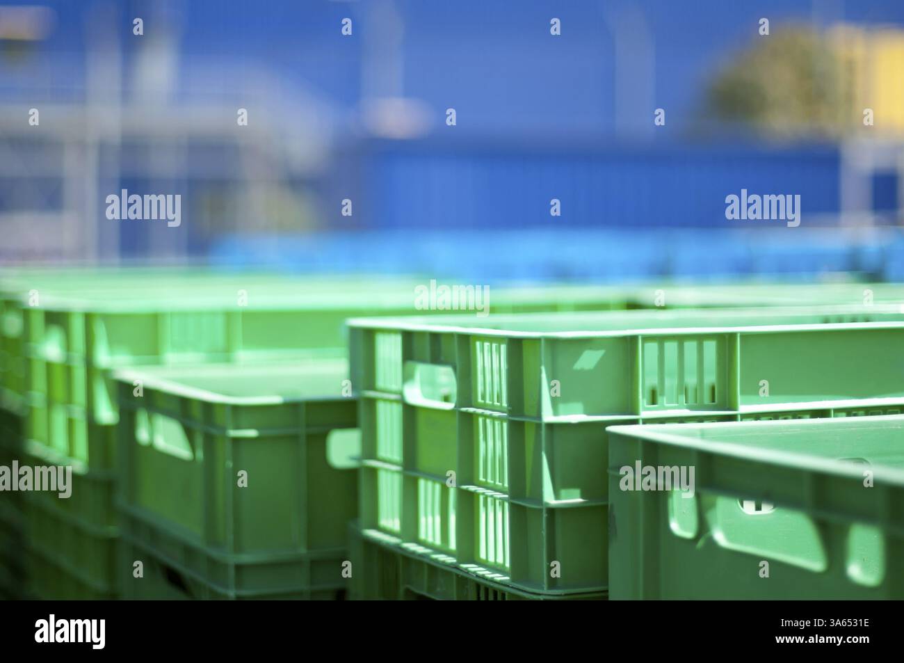Green plastic crates. Blurred blue background Stock Photo - Alamy