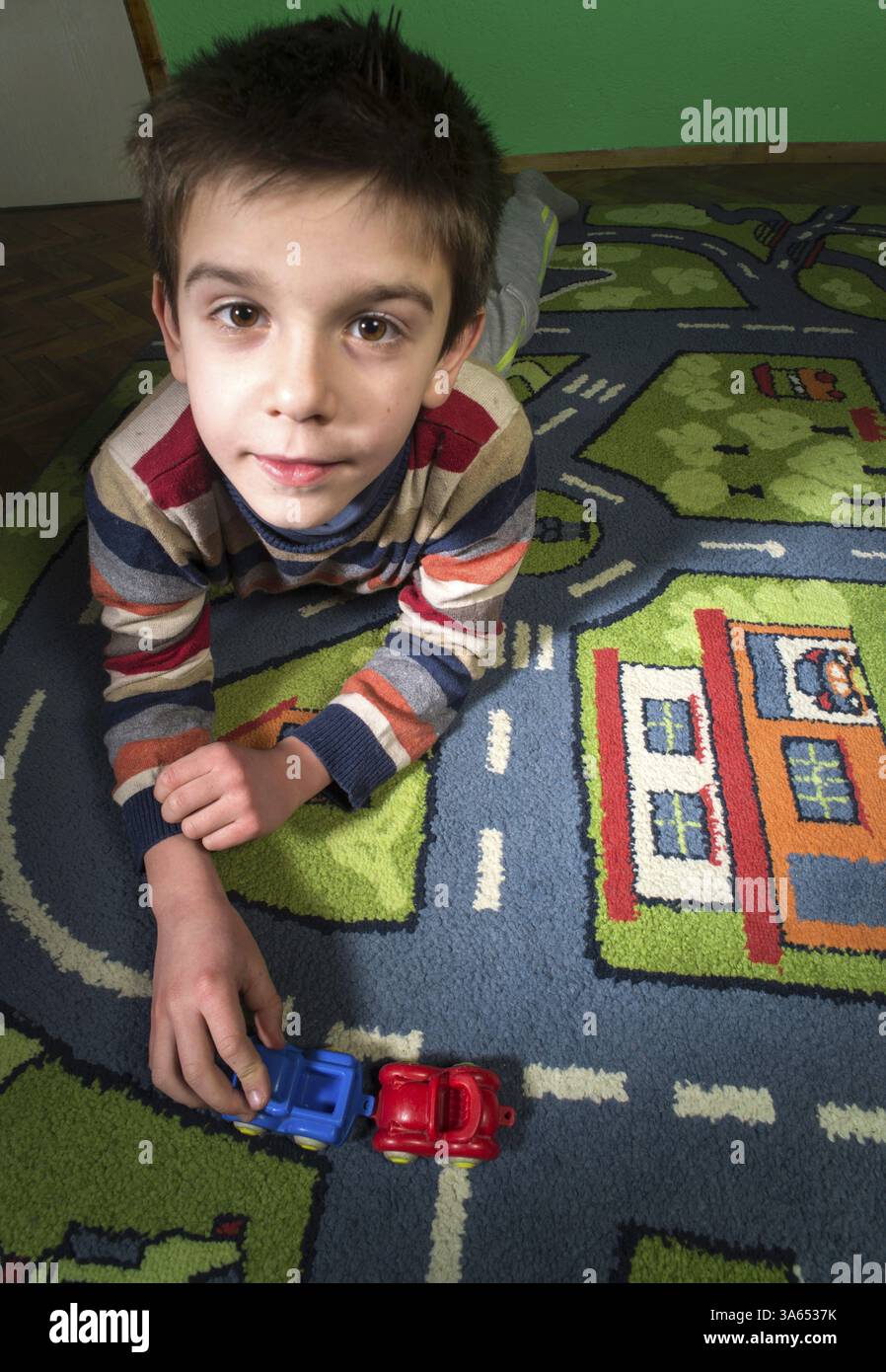 Child is playing with cars on carpet Stock Photo - Alamy