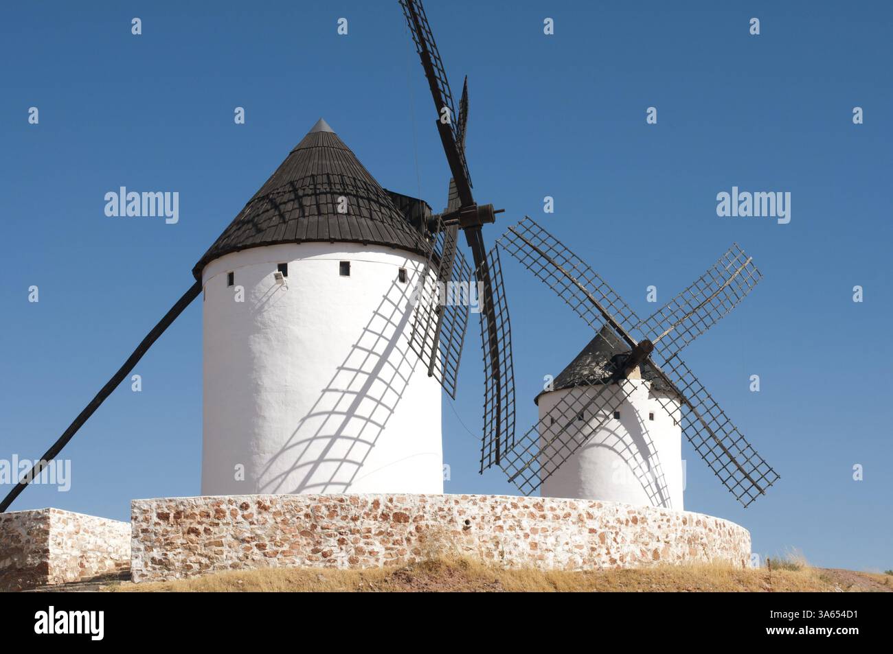 White ancient windmills. Blue sky background Stock Photo - Alamy