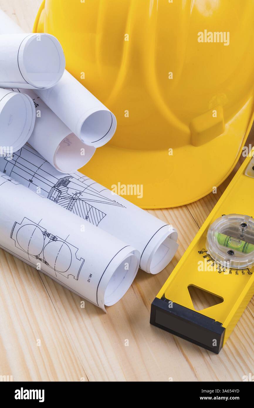 Rolls of blueprints helmet and yellow construction level Stock Photo ...