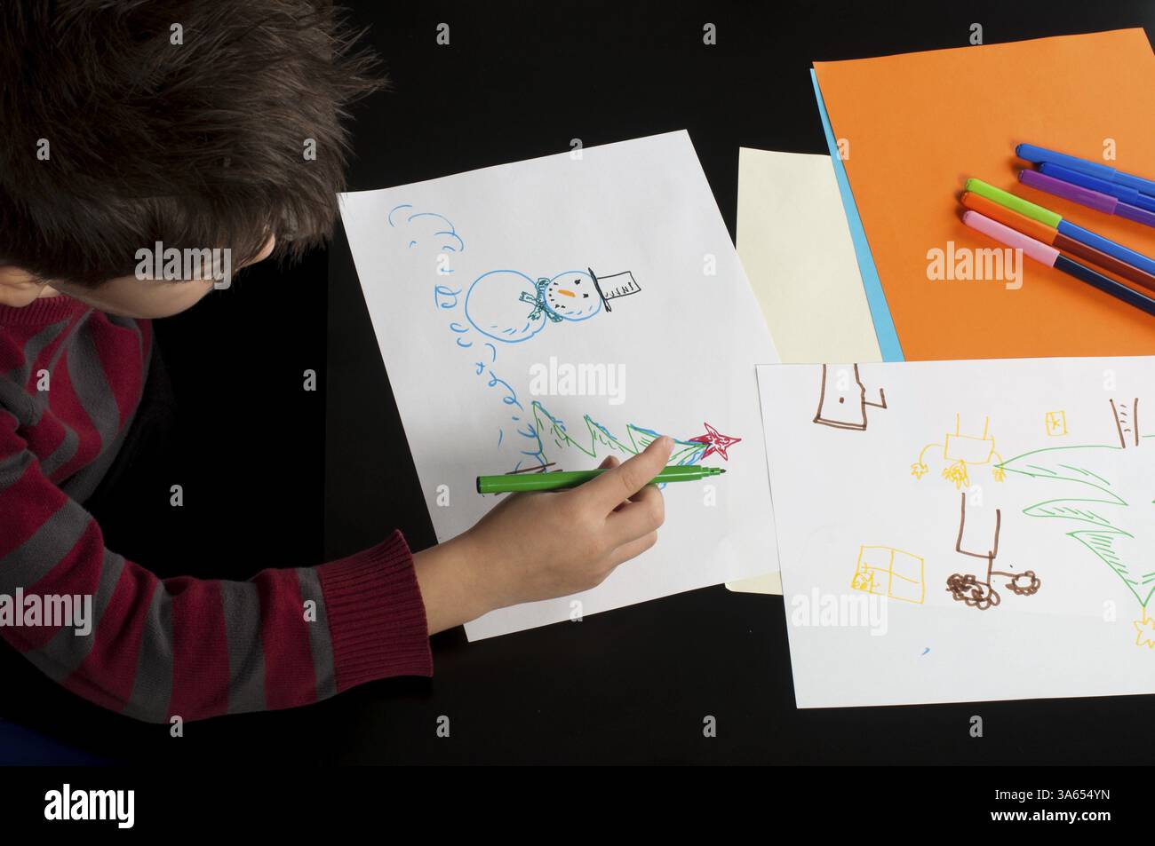 Boy drawing with markers. Multicolored papers Stock Photo - Alamy