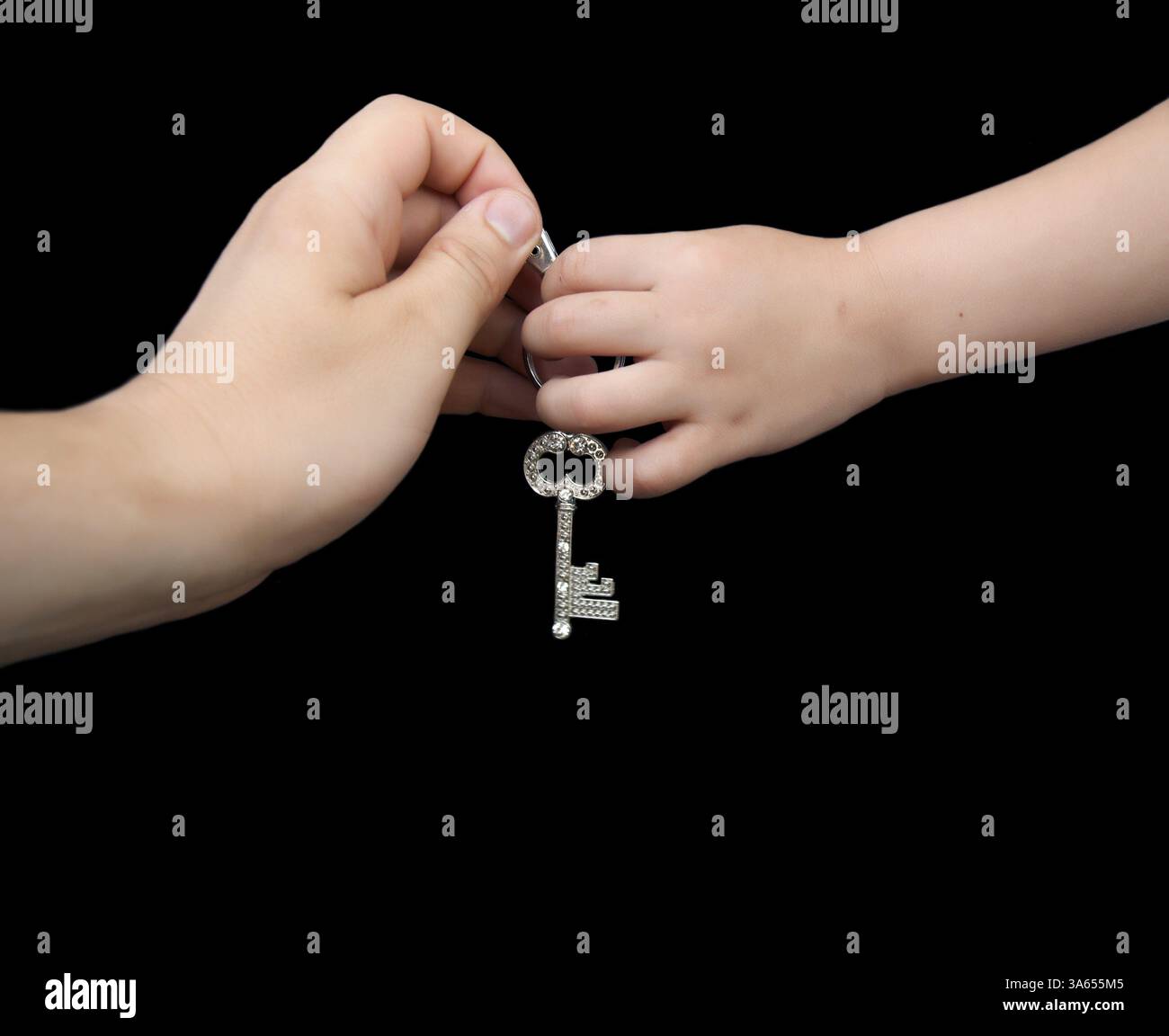 Father giving key to son. Isolated black background Stock Photo - Alamy