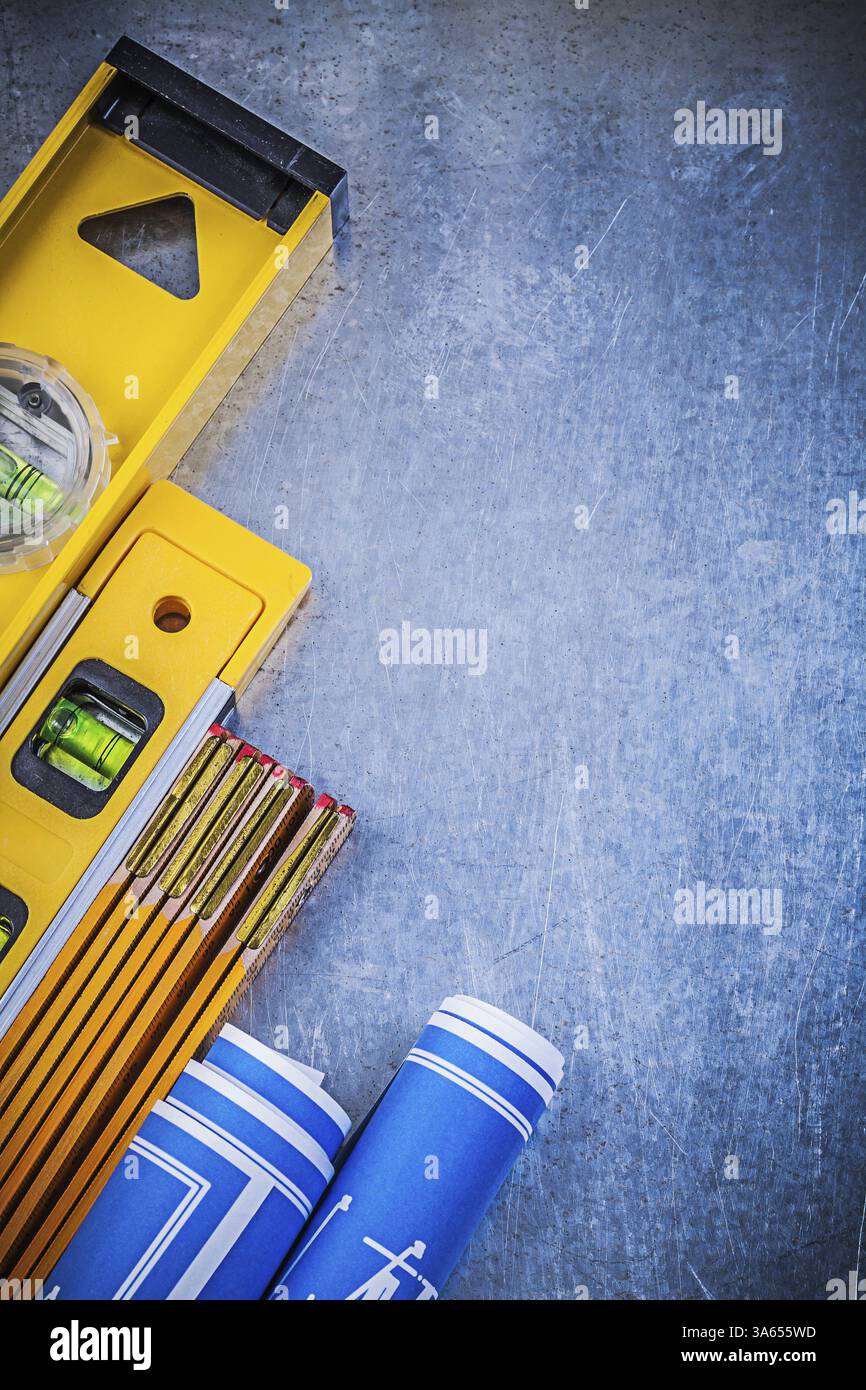 Blue construction drawings levels yellow wooden meter on metallic ...